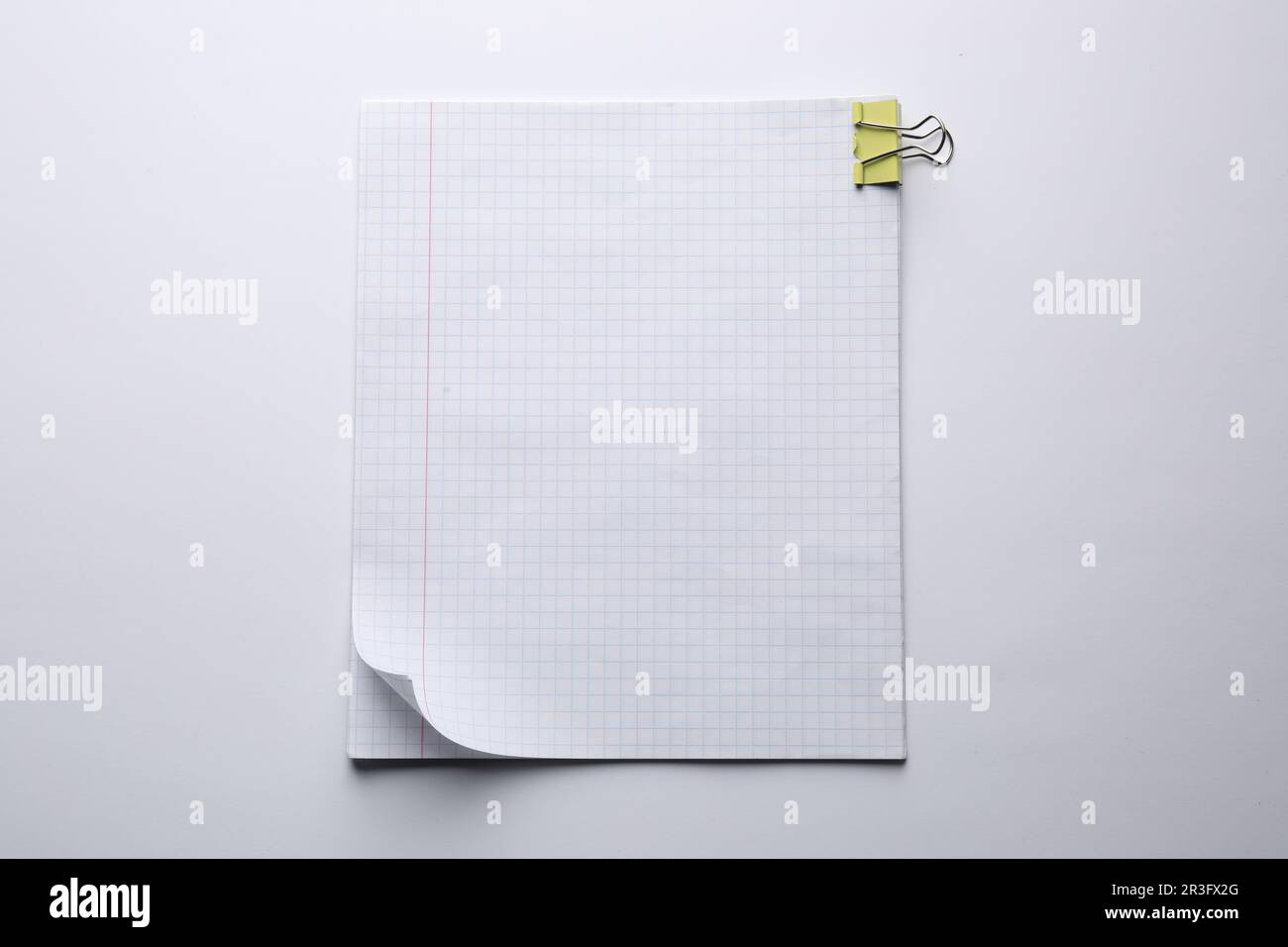 Checkered paper sheets with binder clip on white background, top view ...