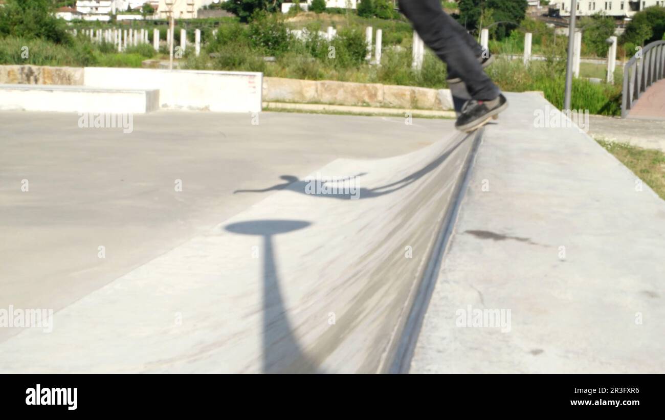 Skateboarder performing a grind trick on a skatepark Stock Photo - Alamy