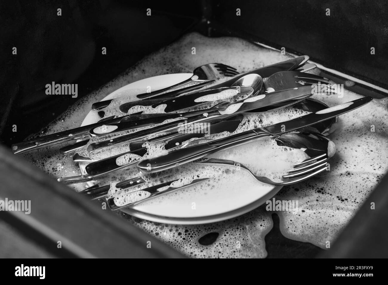 Washing silver spoons, forks and knives in kitchen sink with foam Stock ...