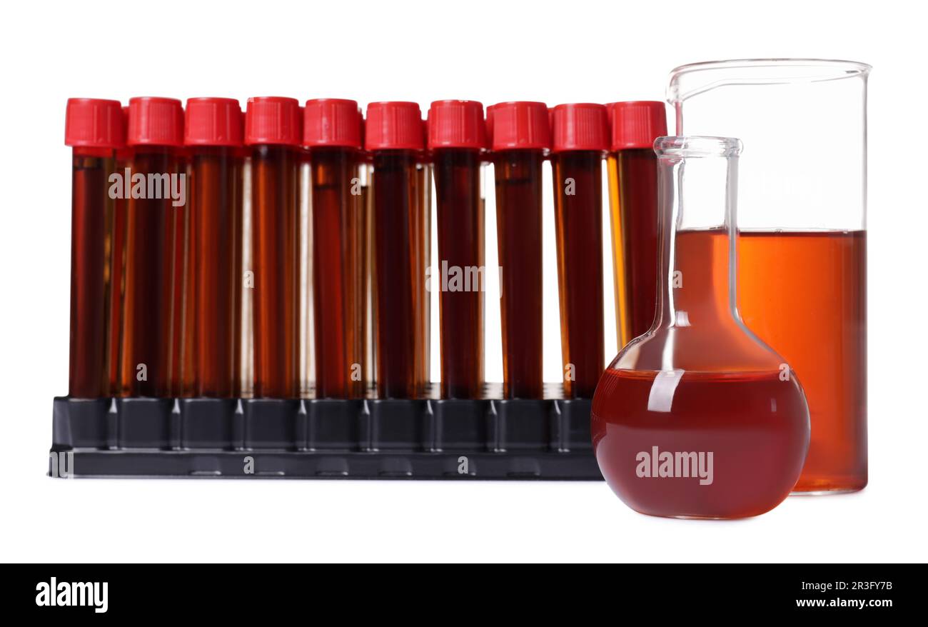 Different laboratory glassware with brown liquids on white background ...