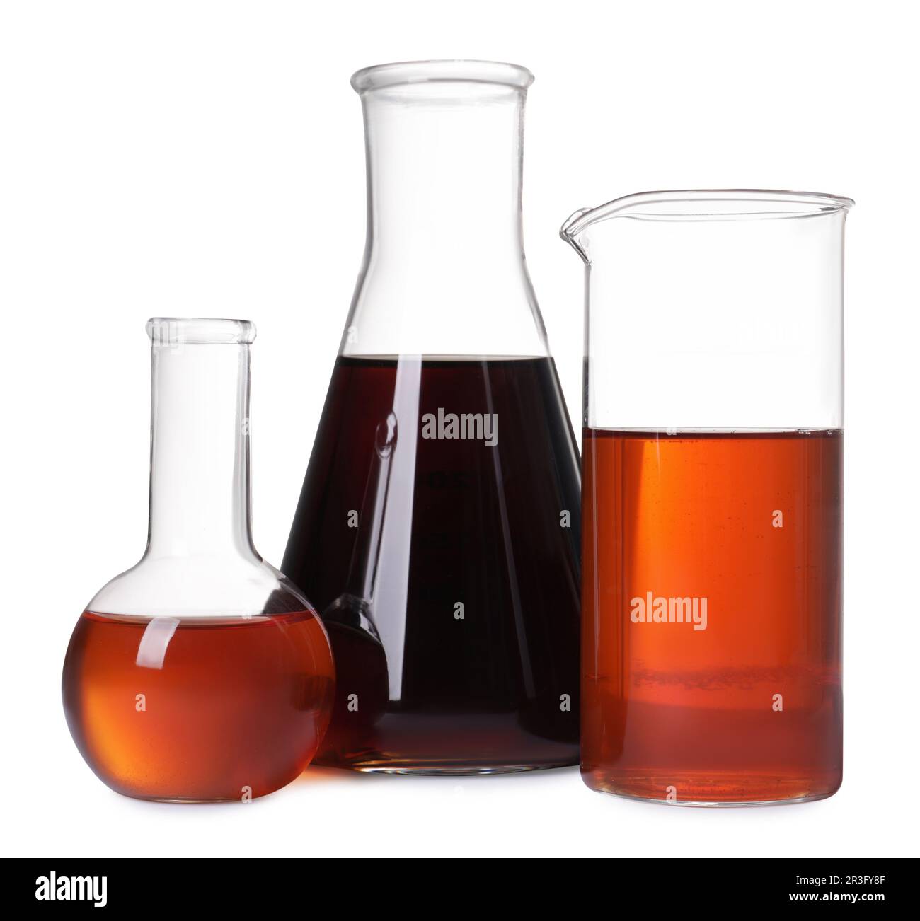 Different laboratory glassware with brown liquids on white background ...