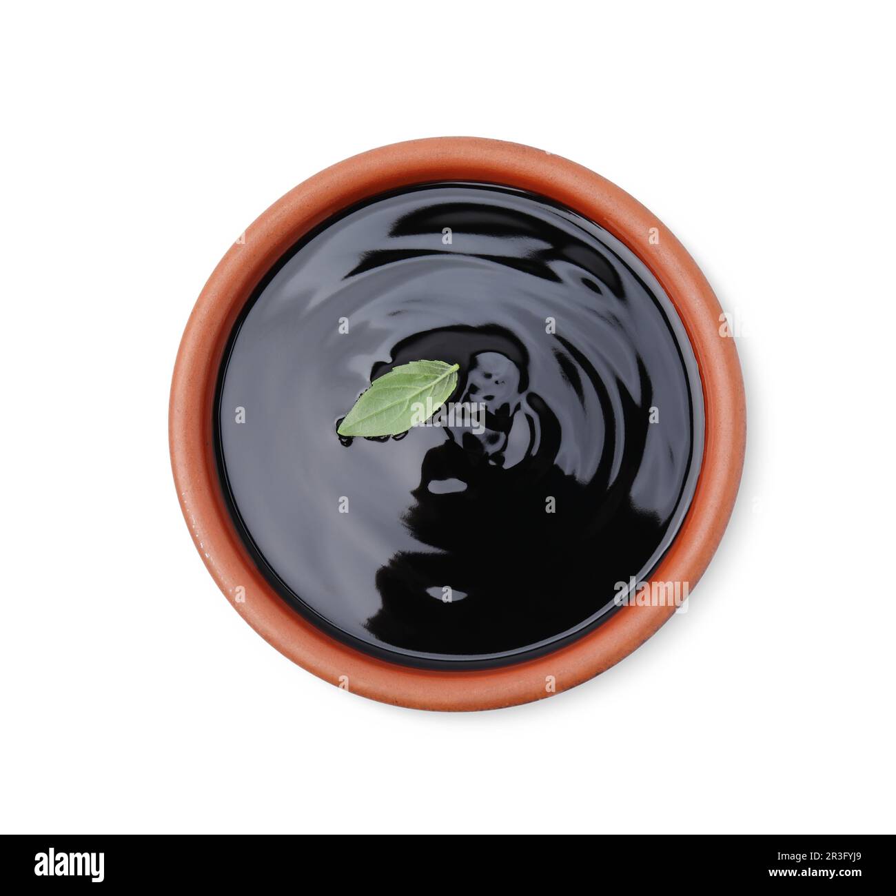 Balsamic glaze with basil leaf in bowl isolated on white, top view ...