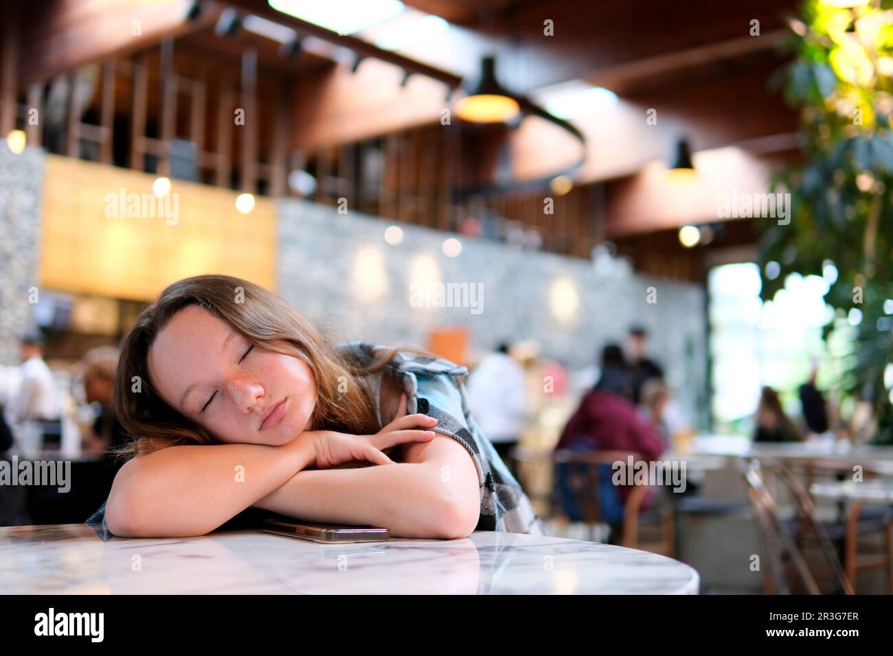 teenage girl fell asleep on table in the restaurant waiting for her ...