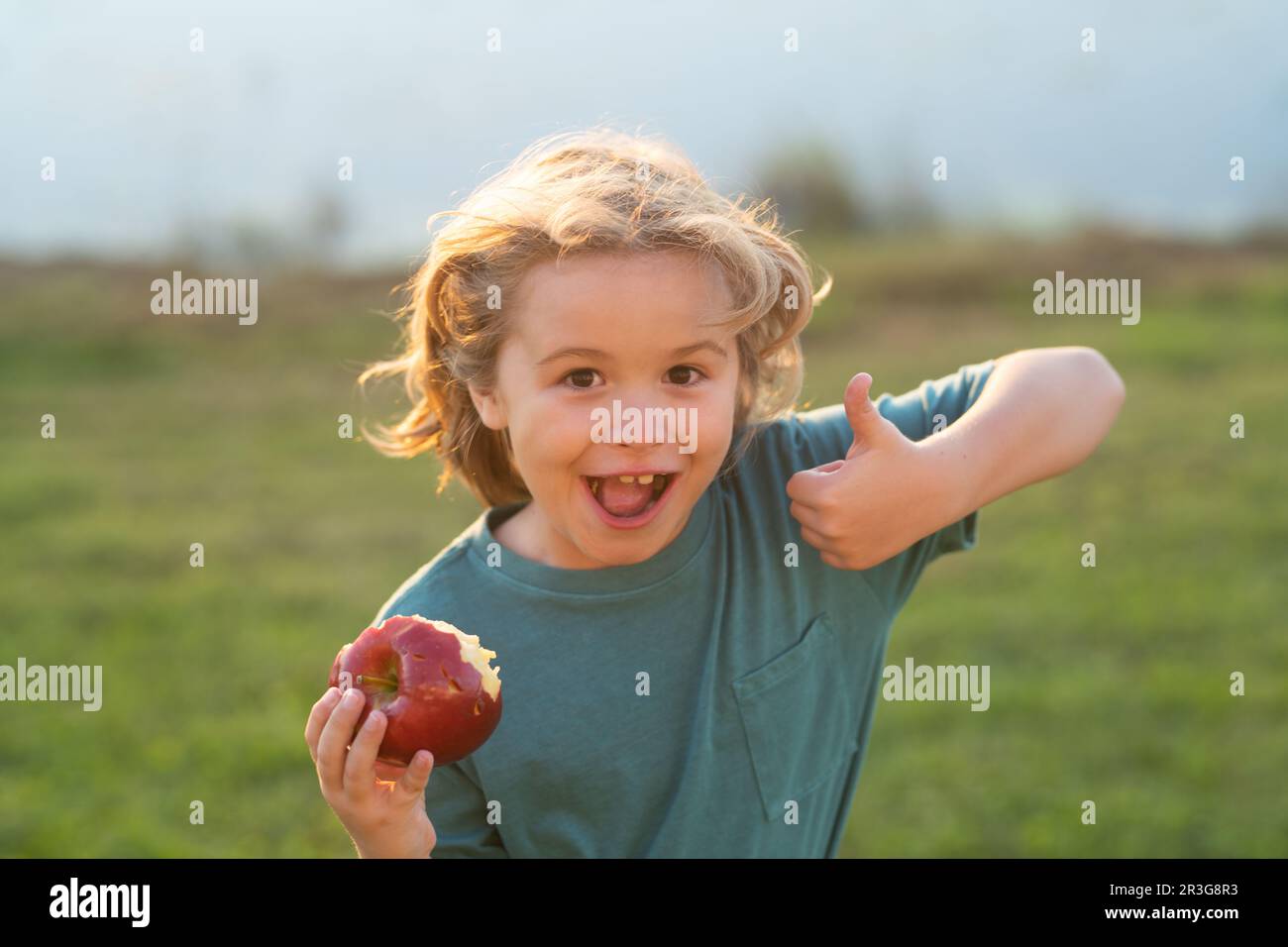 Fresh ripe apple for children. Child with apple outdoor. Boy eating ...