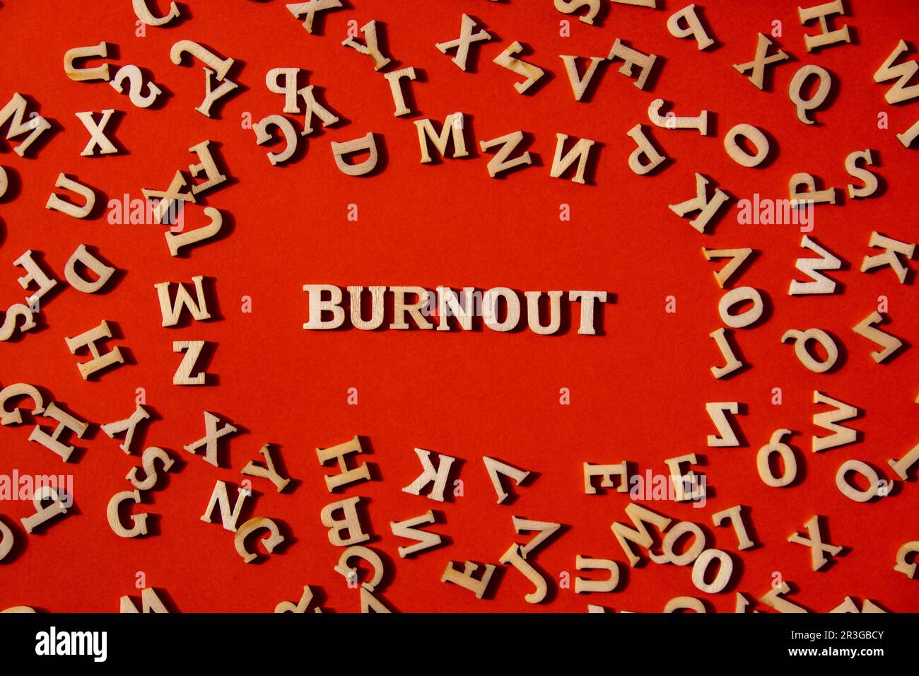 Word BURNOUT made out of wooden letters on bright red background ...