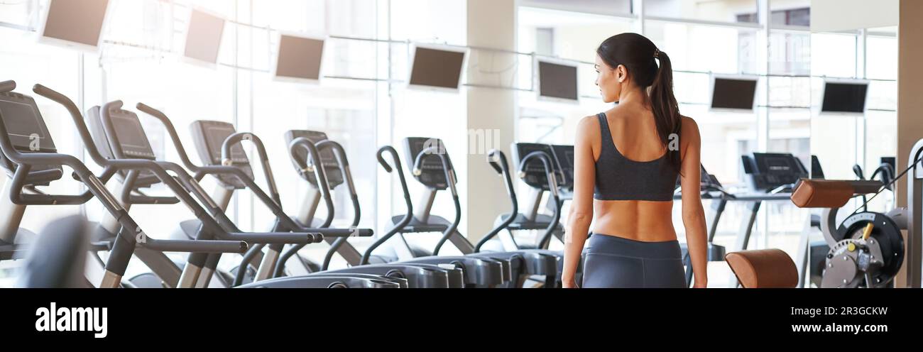 Finishing workout. Back view of short and slim young woman in ...