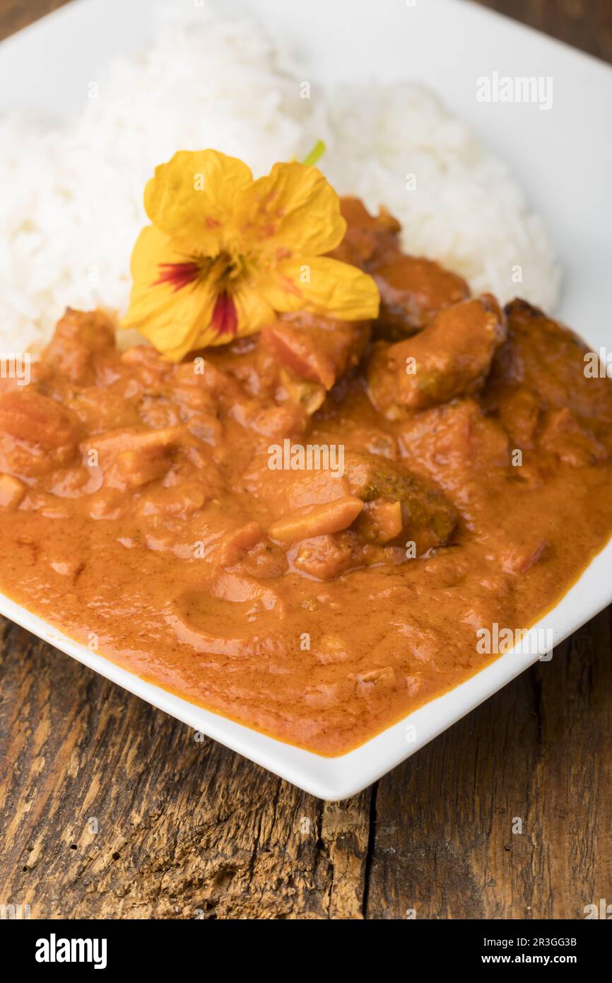Chicken curry with a flower of nasturtium Stock Photo - Alamy
