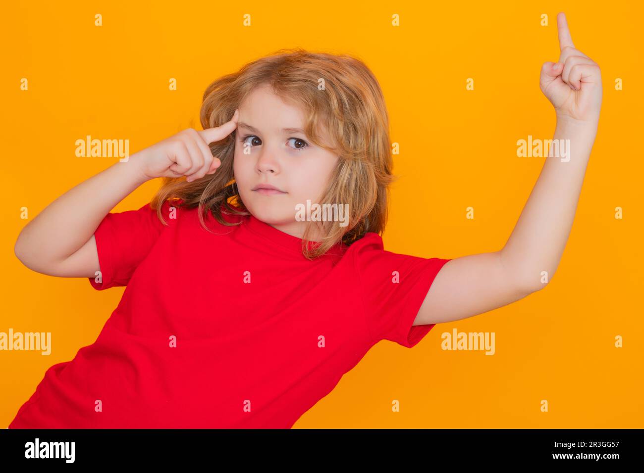 Kid have idea on yellow isolated background. Child boy pointing up ...
