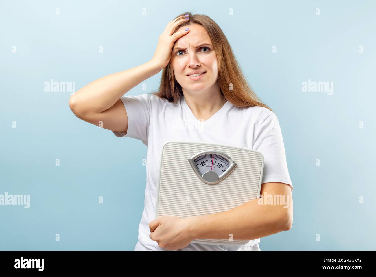 Young woman with hand on head, shocked with shame face holding white ...