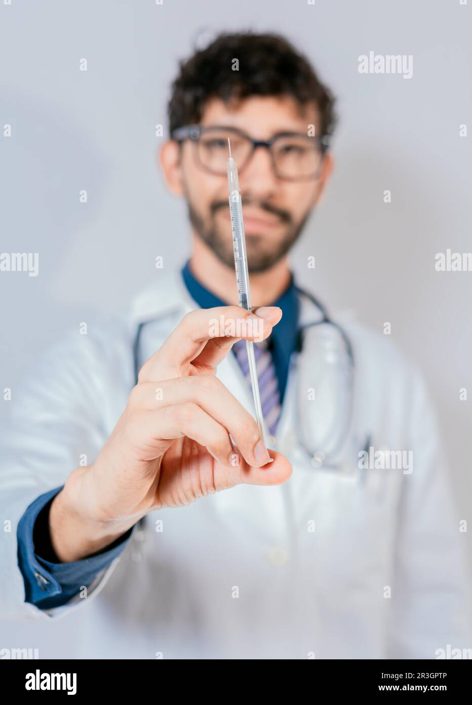 Close up of doctor holding a syringe isolated. Smiling doctor holding a ...
