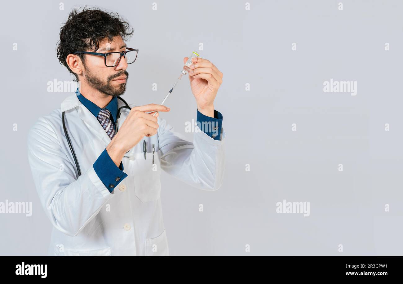 Young doctor drawing medicine from a vial with copy space. doctor ...