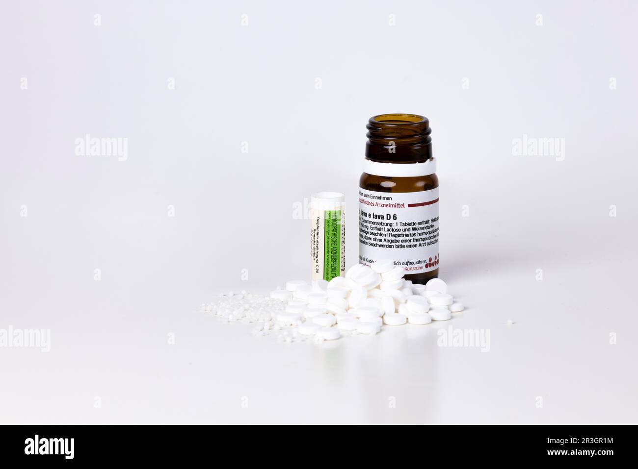 Homeopathic remedies lie in front of containers, tablets and globules ...