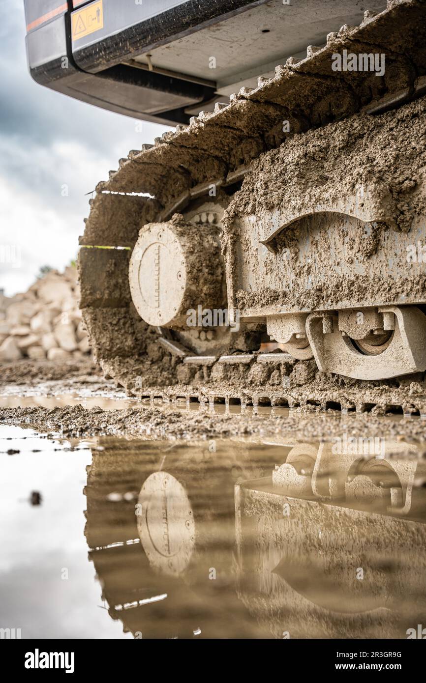 Tracked excavator in dirt with puddle Stock Photo - Alamy