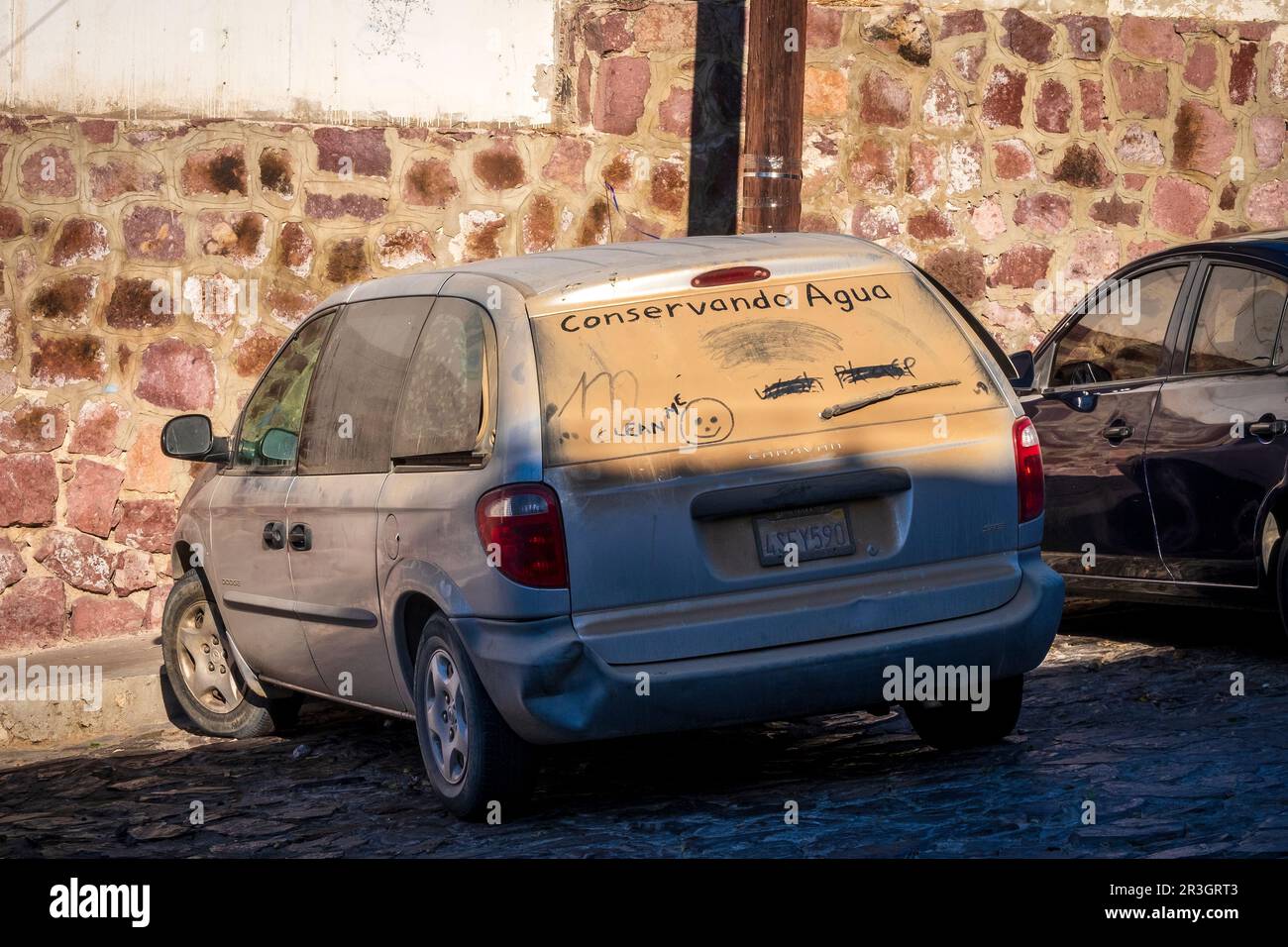 Dirty car with the words "Conservando agua, clean me, wash me please ...