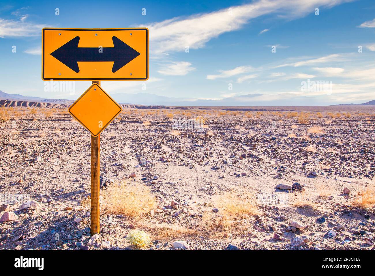 Directional sign in the desert with scenic blue sky and wide horizon ...