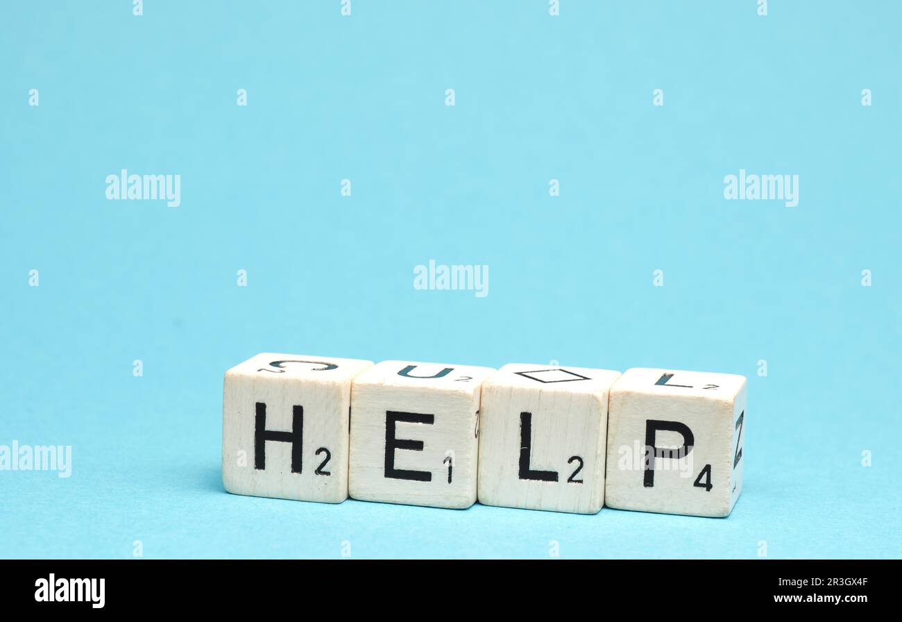 Wooden blocks with the word help on a blue background, faq or service ...