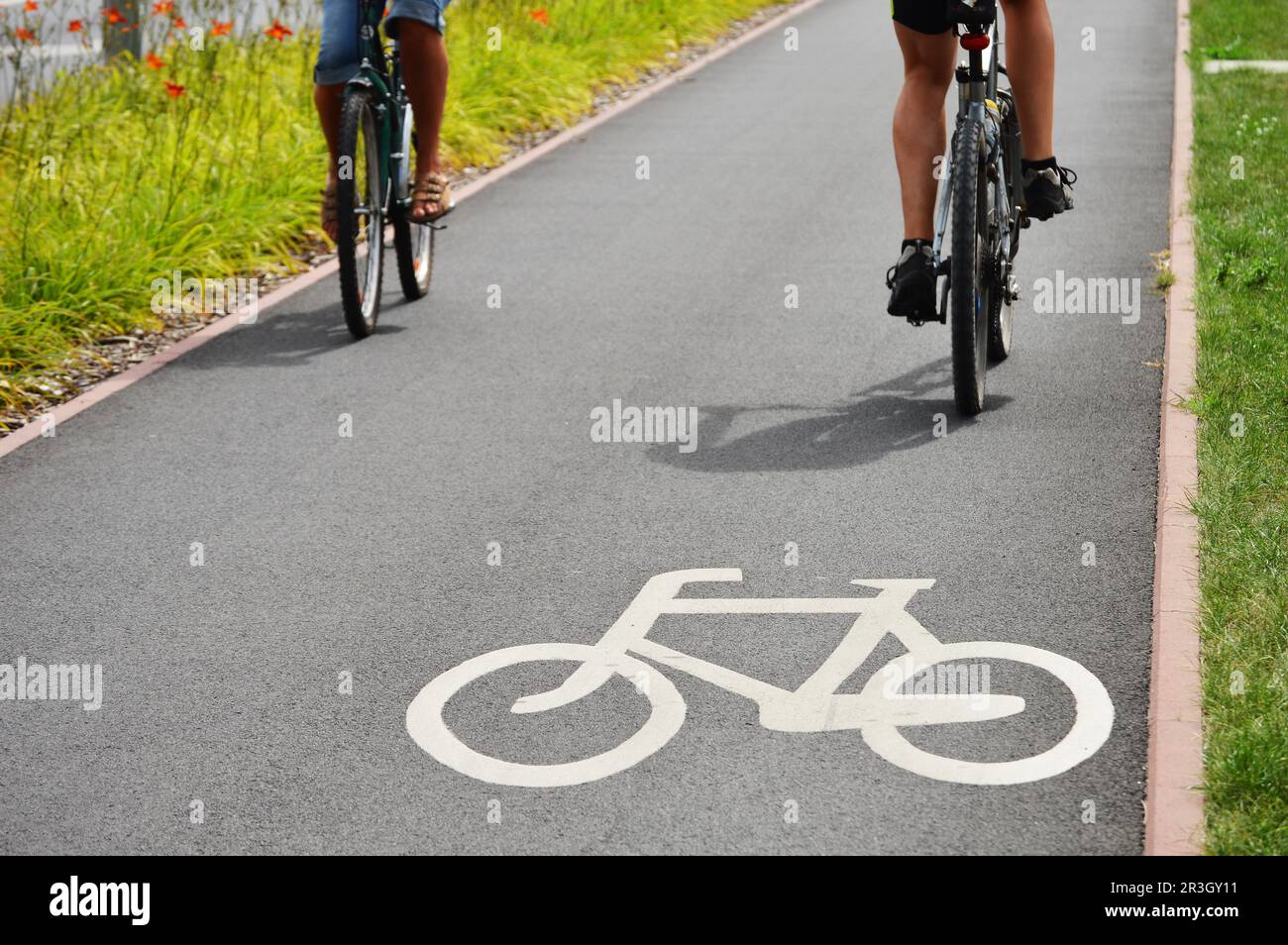 Bicycle road sign and bike riders Stock Photo - Alamy