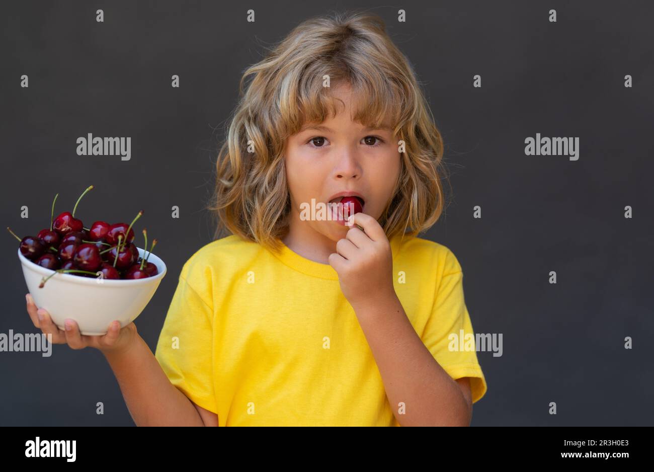Cherry fot kids. Happy kid eating ripe, sweet, juicy, fresh cherries ...
