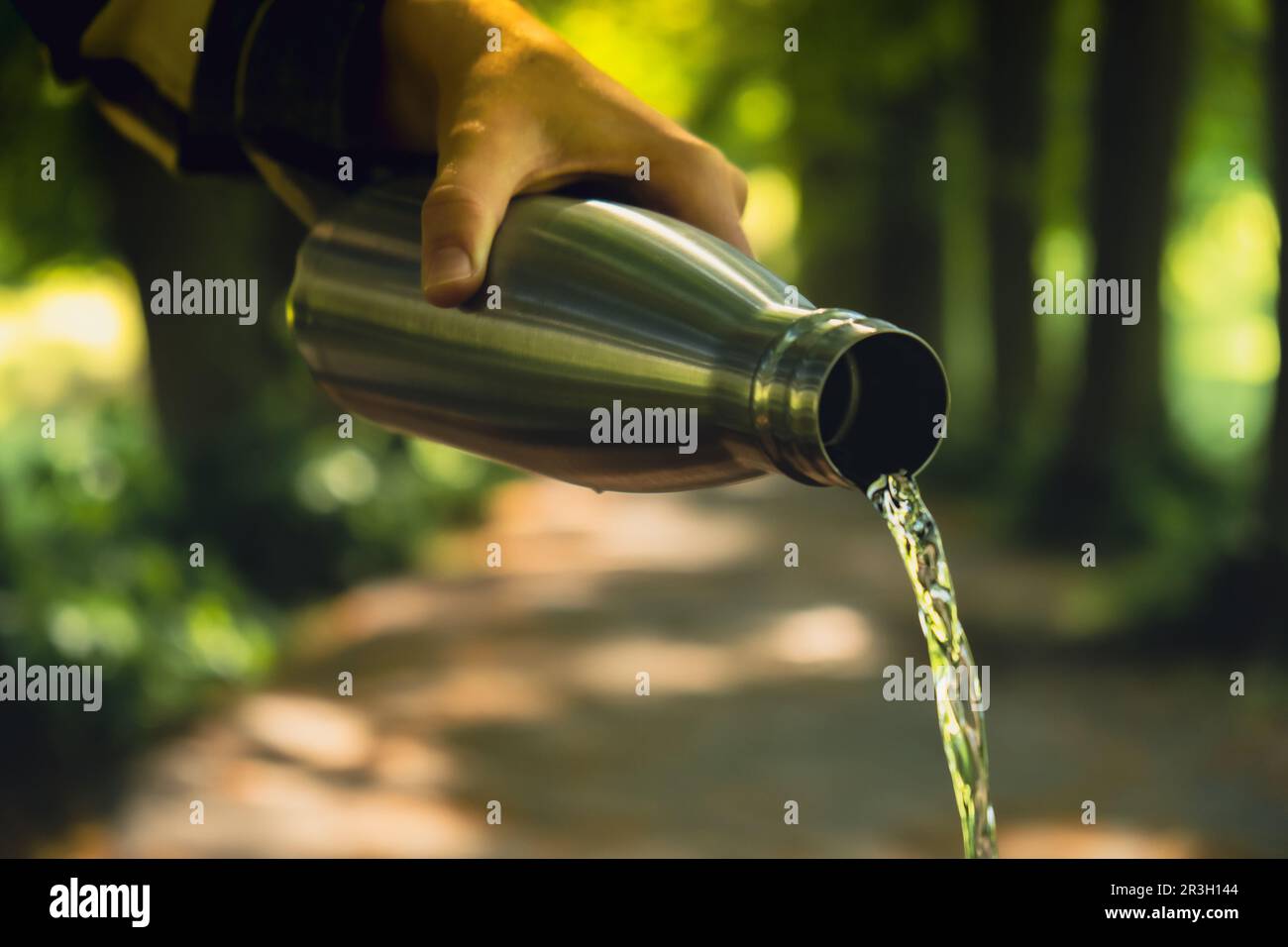 Close-up of Unrecognizable female hand holding Water bottle. Pouring ...