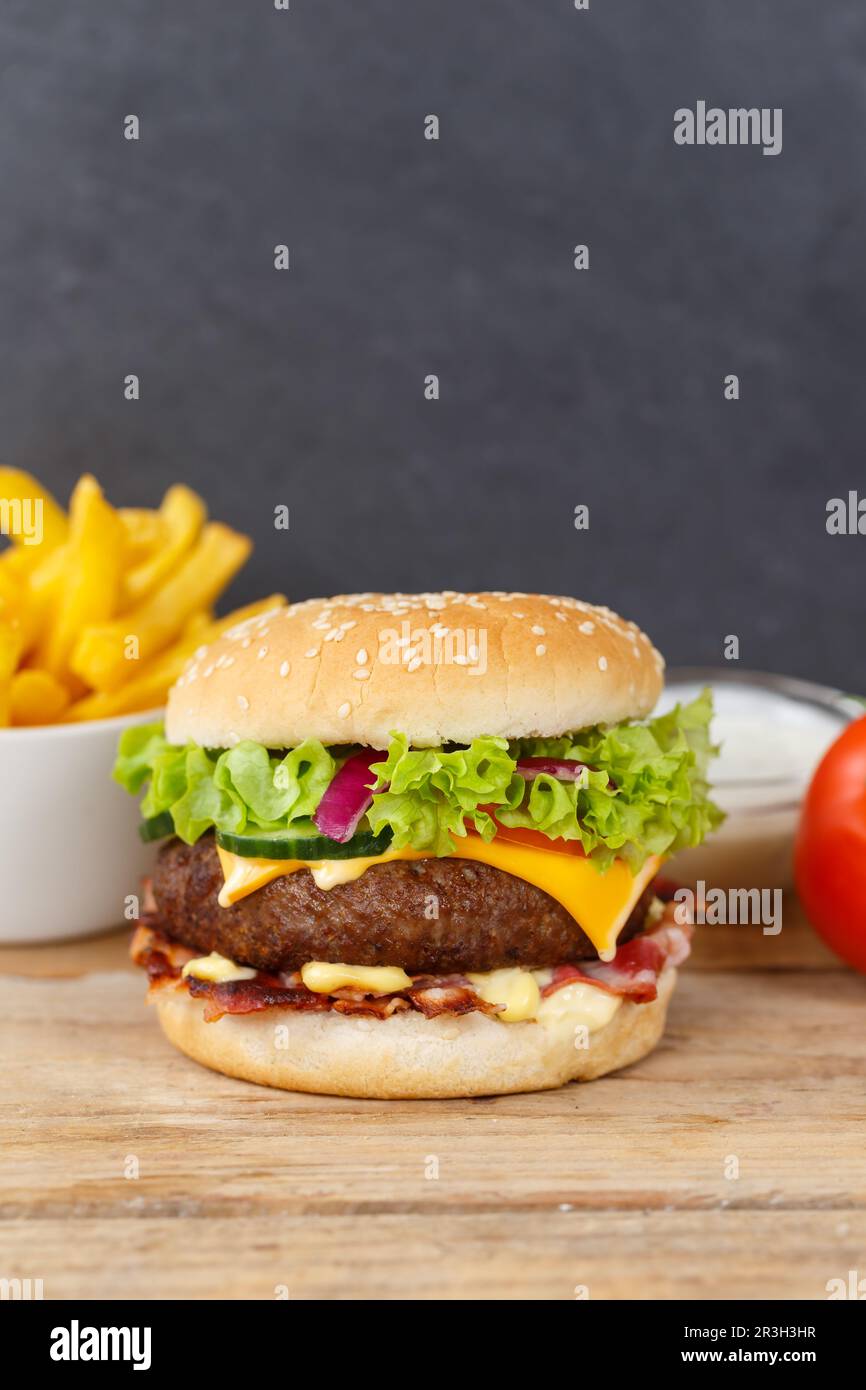 Hamburger cheeseburger fast food meal menu with fries on wooden board ...