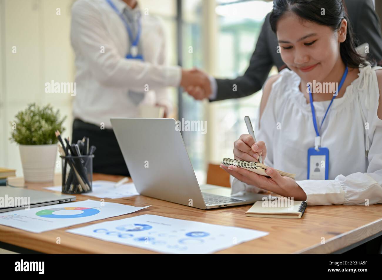 A beautiful young Asian female assistant or secretary taking notes on ...