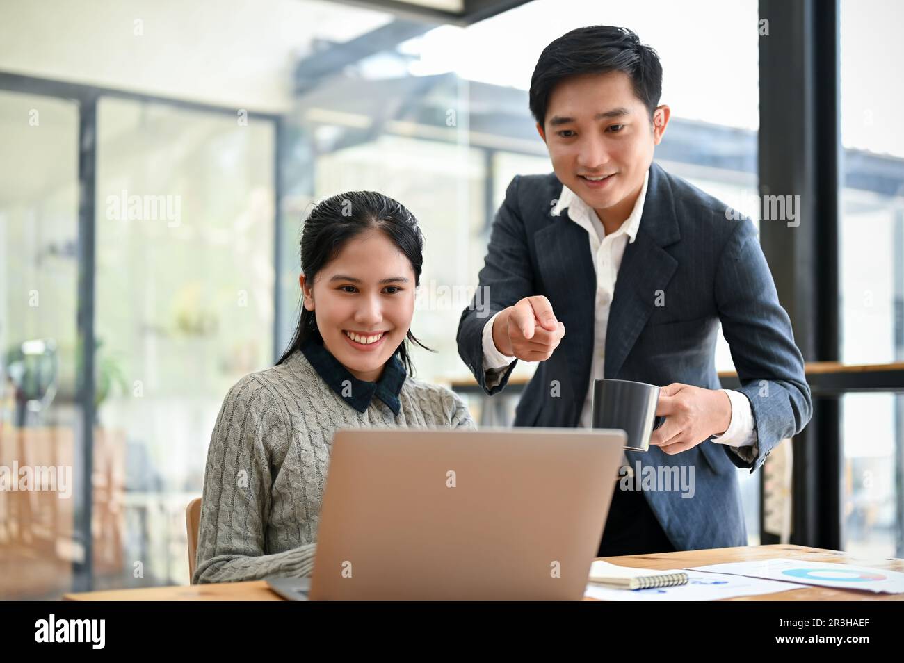 A young Asian female marketing assistant working on a new project with ...