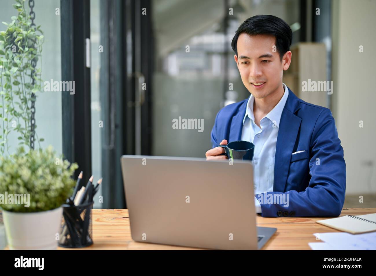 A handsome Asian businessman or male banker in a formal business suit ...