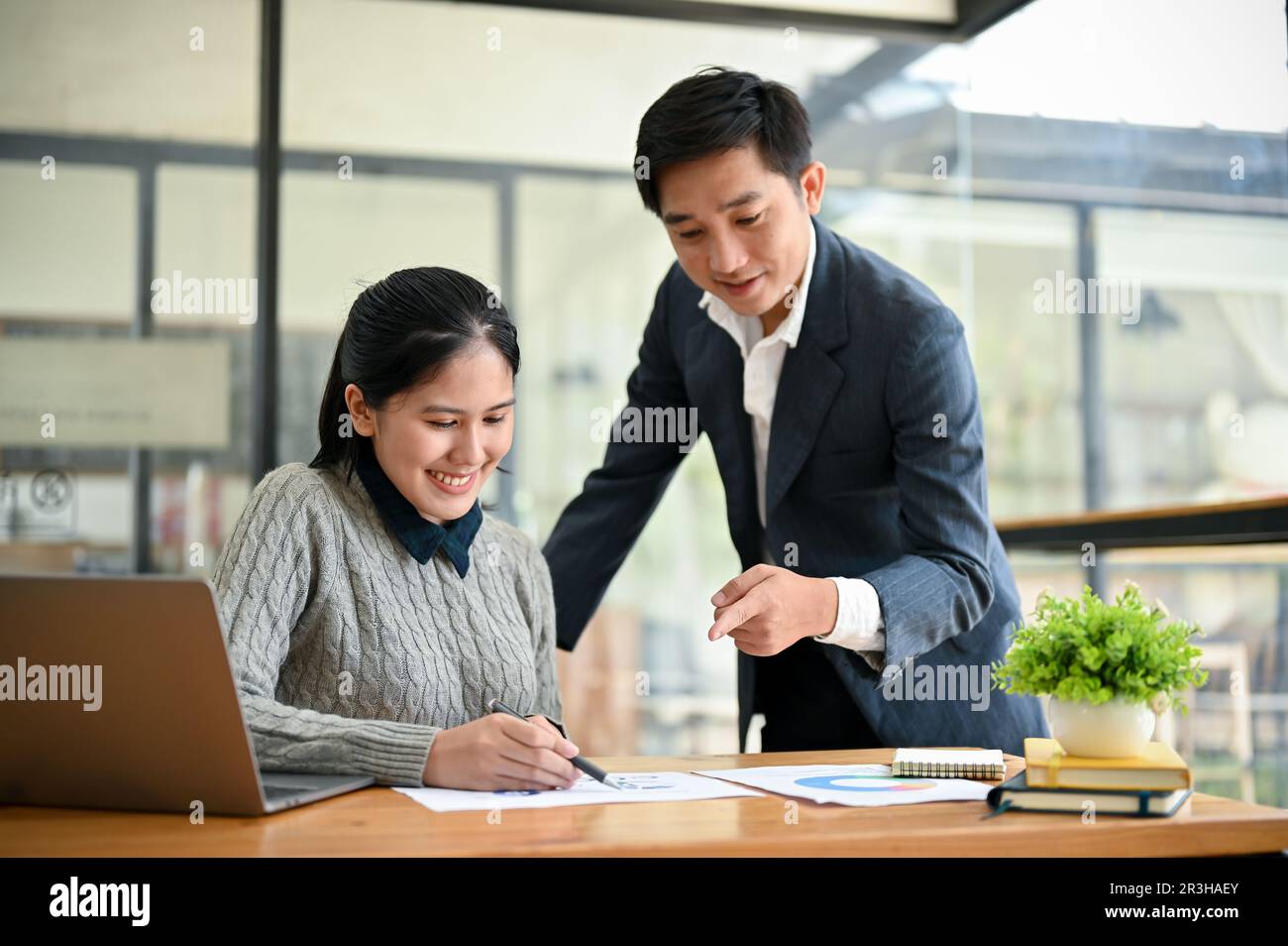 A kind and professional millennial Asian male boss is training and ...