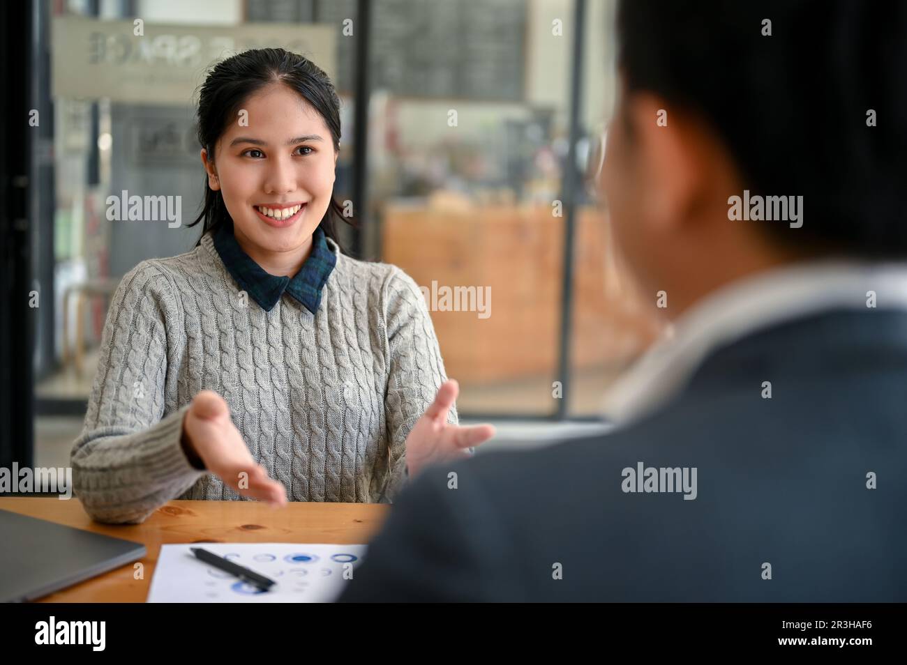 A smiling and charming young Asian female office worker sharing her ...
