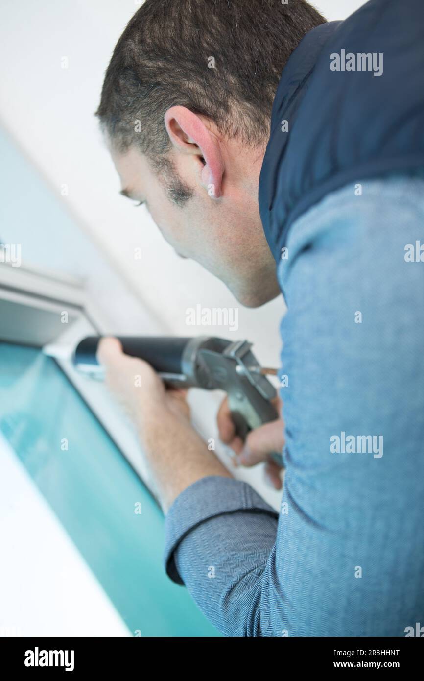 close view of man applying silicone around a window Stock Photo - Alamy
