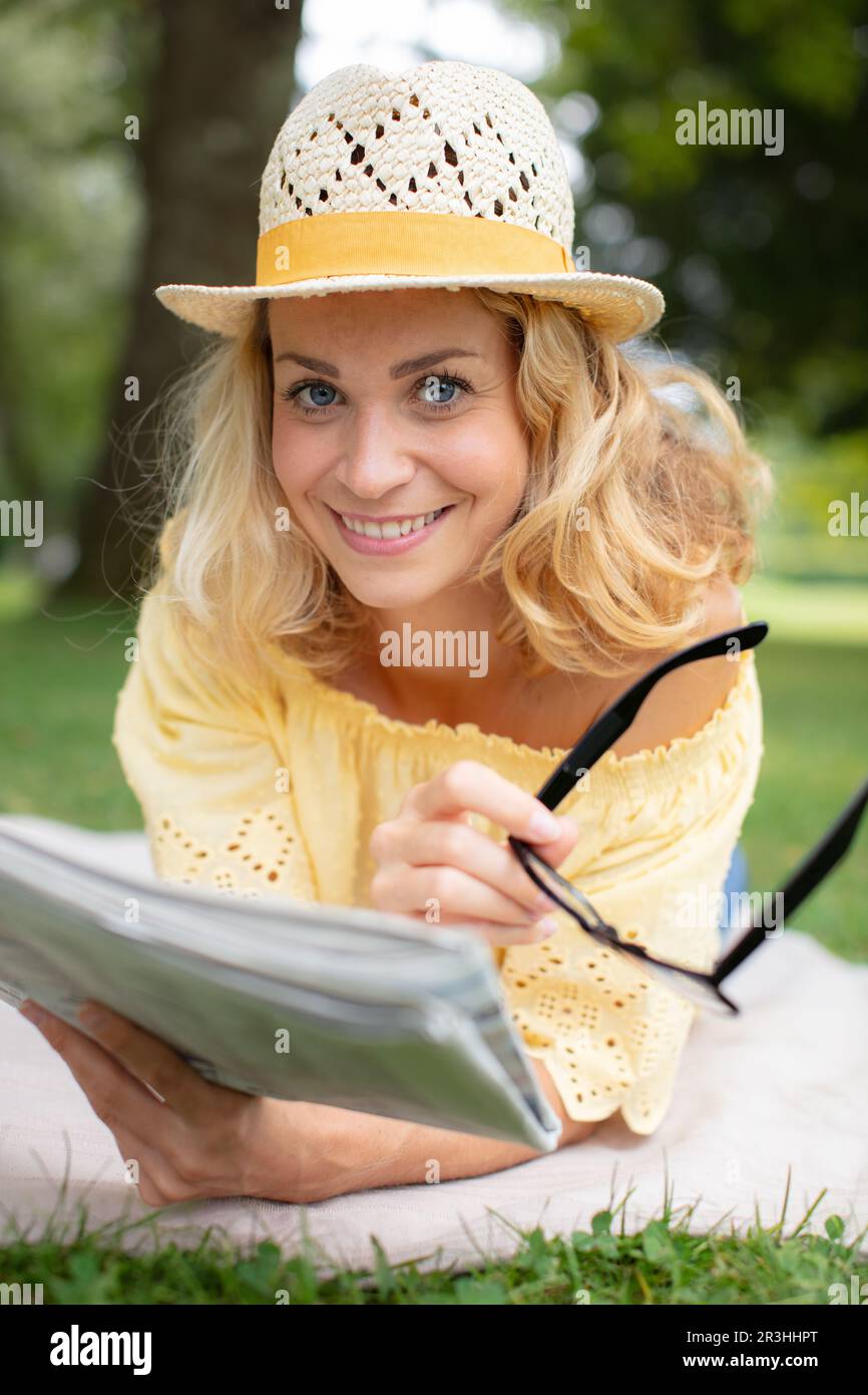 woman layed on the grass reading the newspaper Stock Photo - Alamy