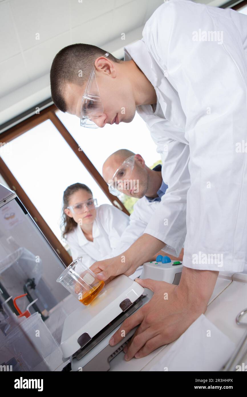 young life science professional pipetting solution into the glass ...