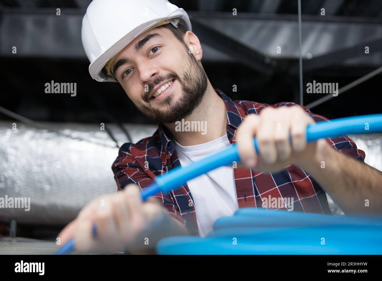 portrait of an engineer holding pipes Stock Photo - Alamy