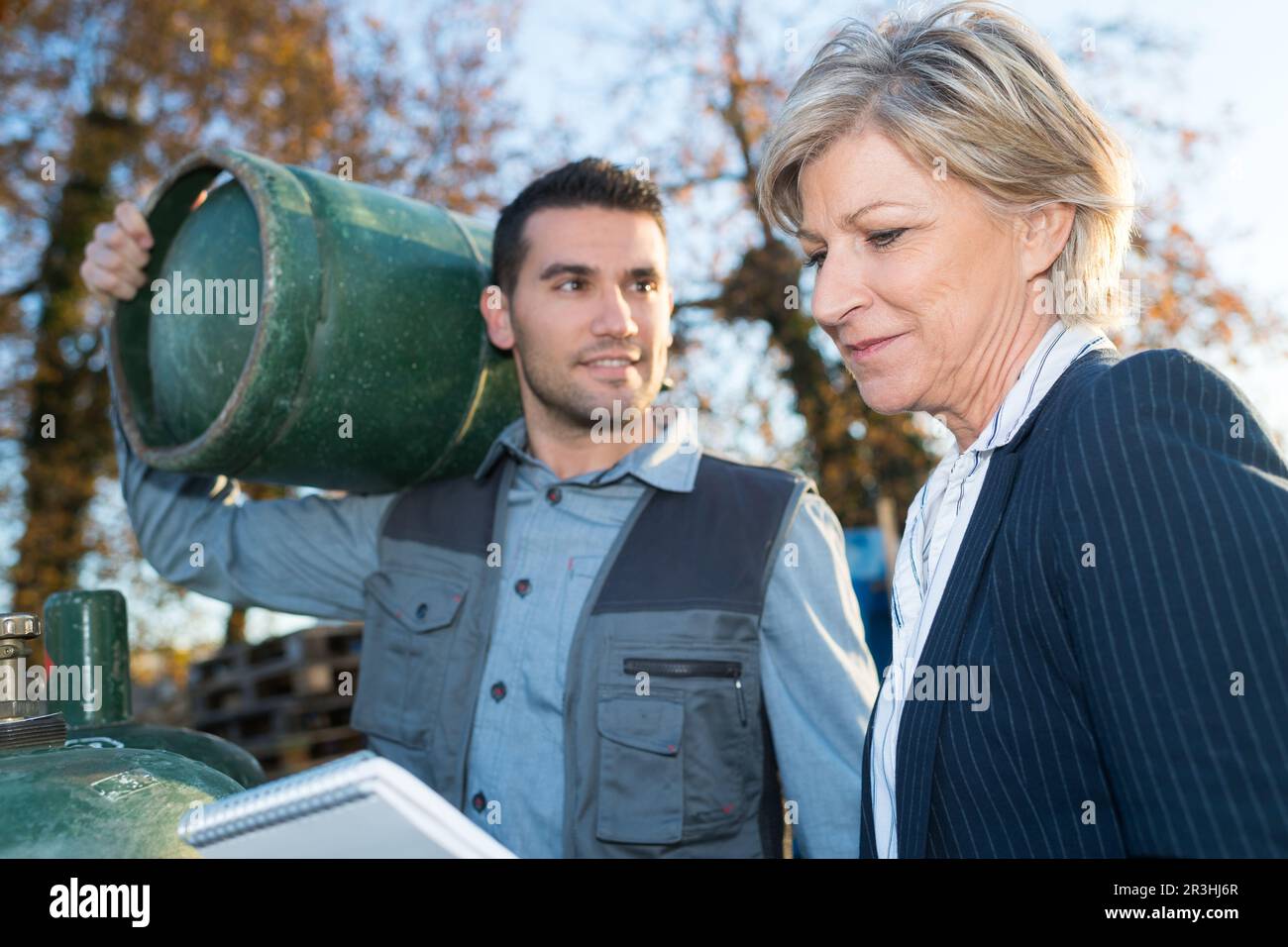 worker carrying refillable empty tank Stock Photo - Alamy