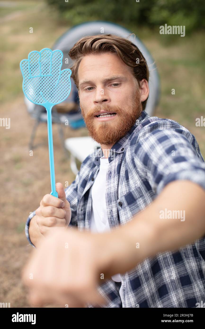a man camping is killing flies Stock Photo - Alamy