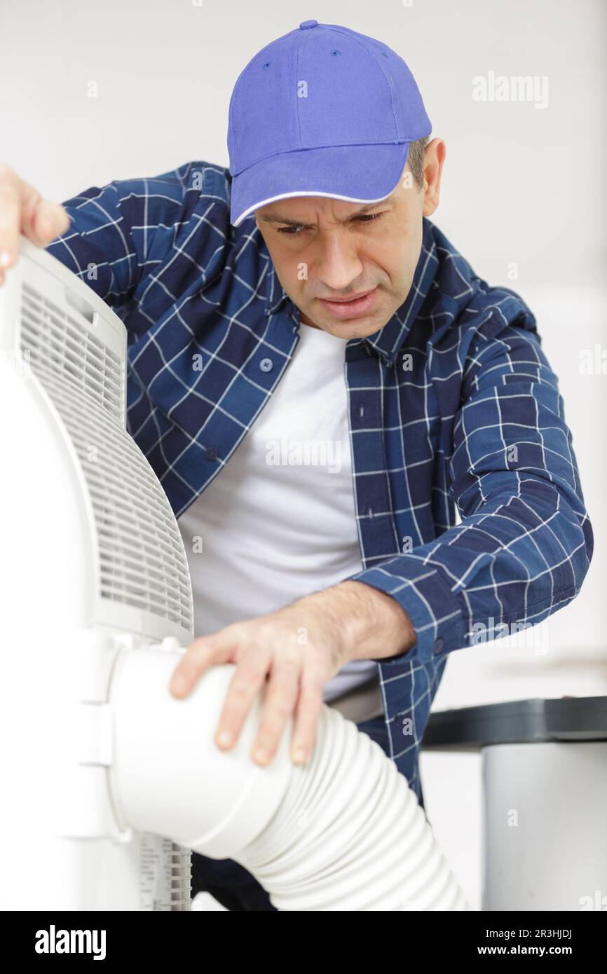 male technician assembling hose to air conditioning unit Stock Photo ...