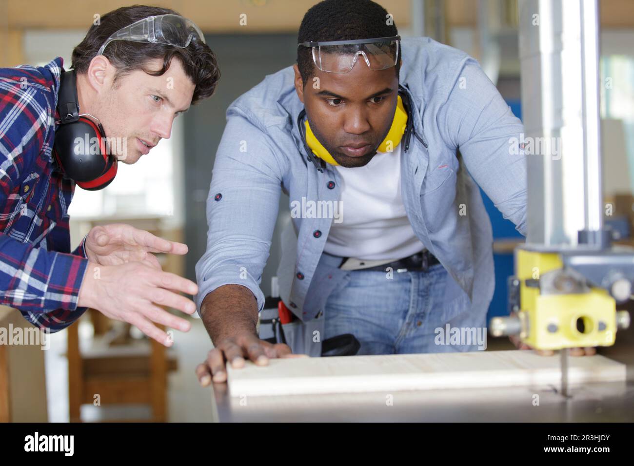 apprentice learning how to use bench saw Stock Photo - Alamy