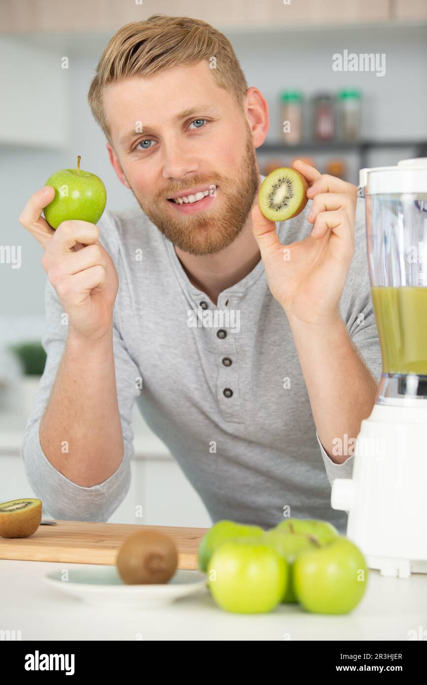 happy man making juice or smoothie in kitchen Stock Photo - Alamy