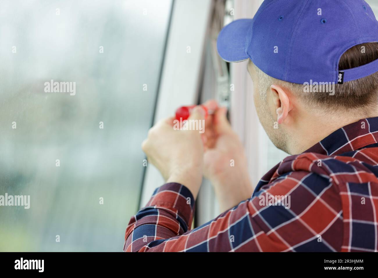 service man installing window with screwdriver Stock Photo - Alamy