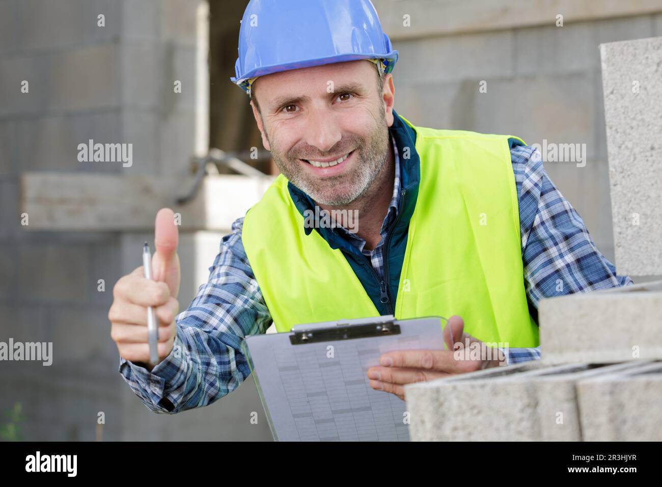 positive foreman with clipboard on site holding thumbs-up Stock Photo ...