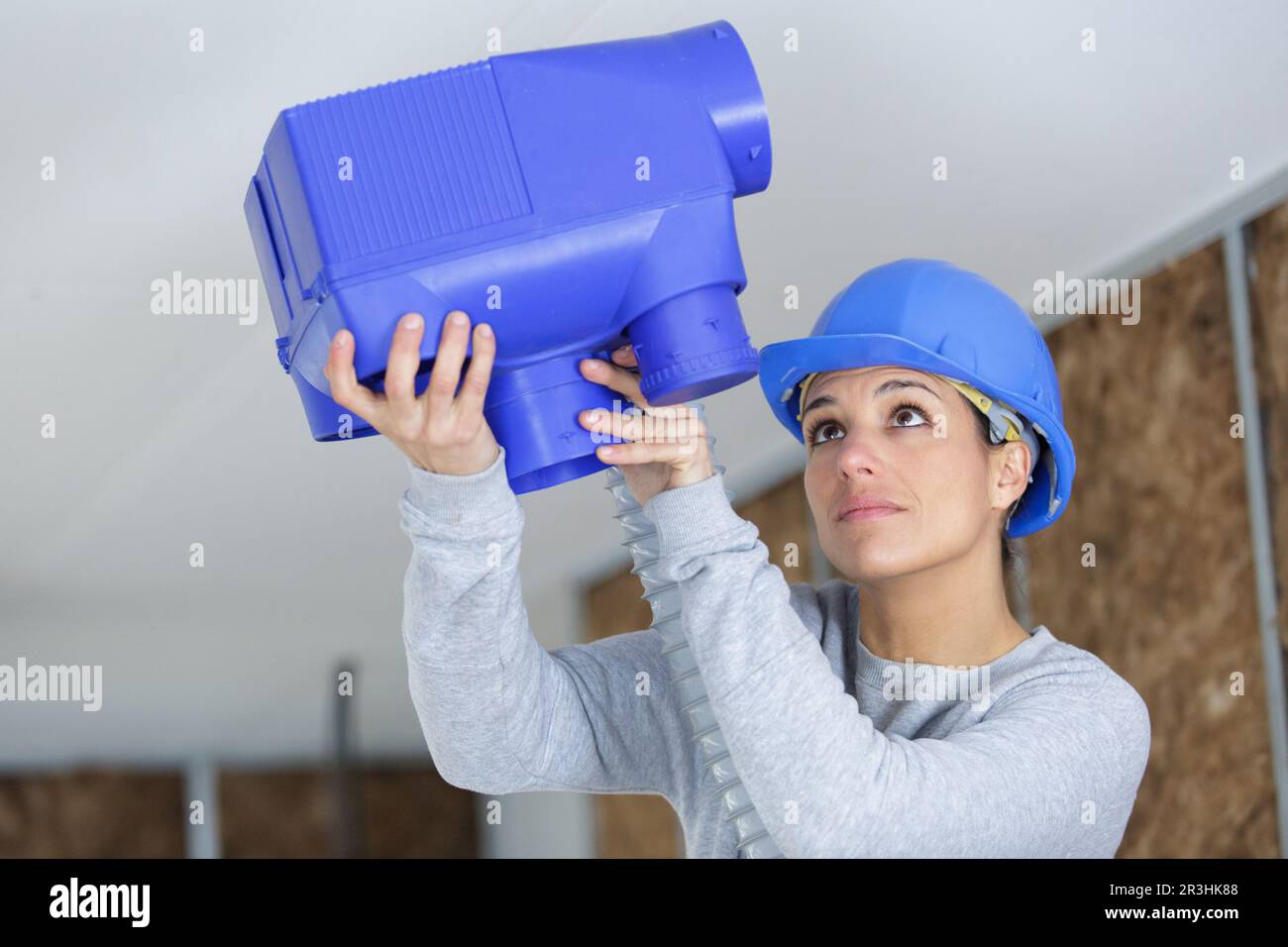 young female worker installing plastic ventilation unit Stock Photo - Alamy