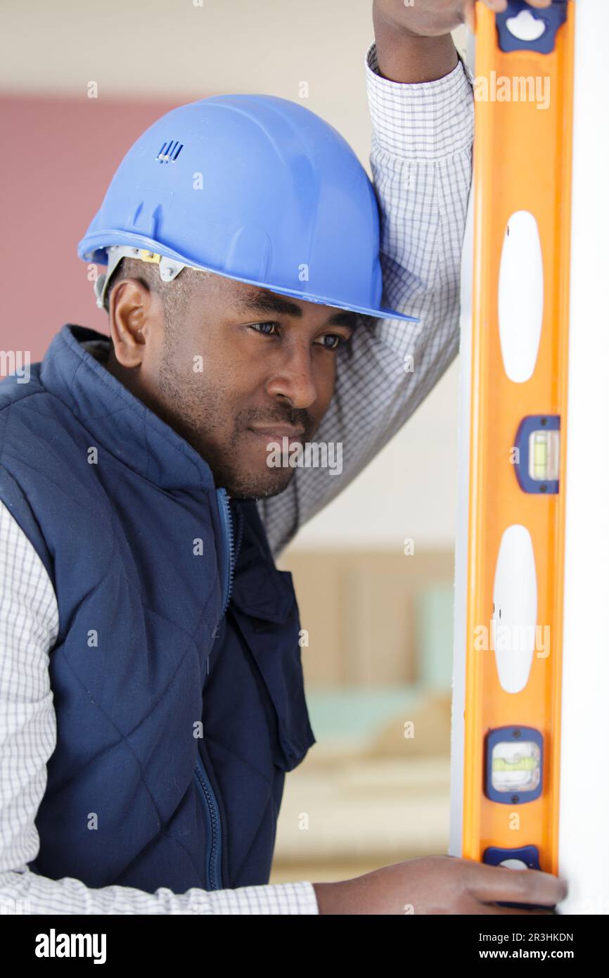 builder working with level near the fiberboard wall Stock Photo - Alamy