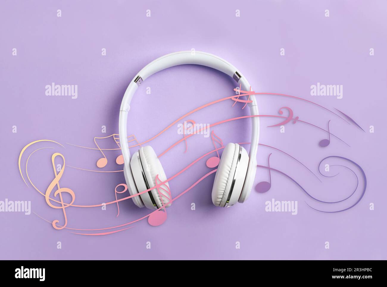 Staff with music notes and treble clef flowing over white headphones on ...