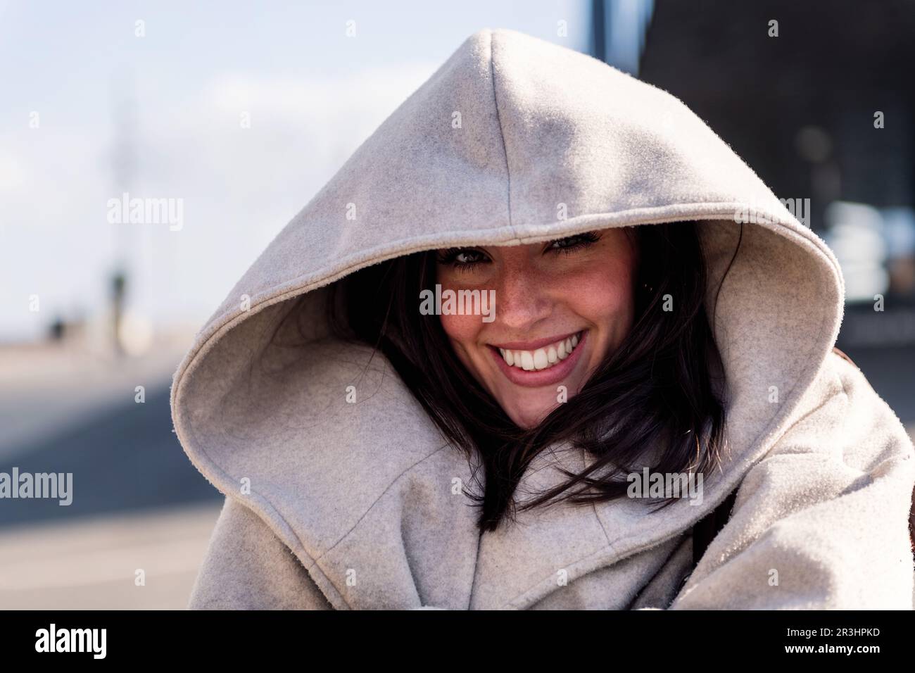 joyful young woman hiding under her coat hood Stock Photo - Alamy
