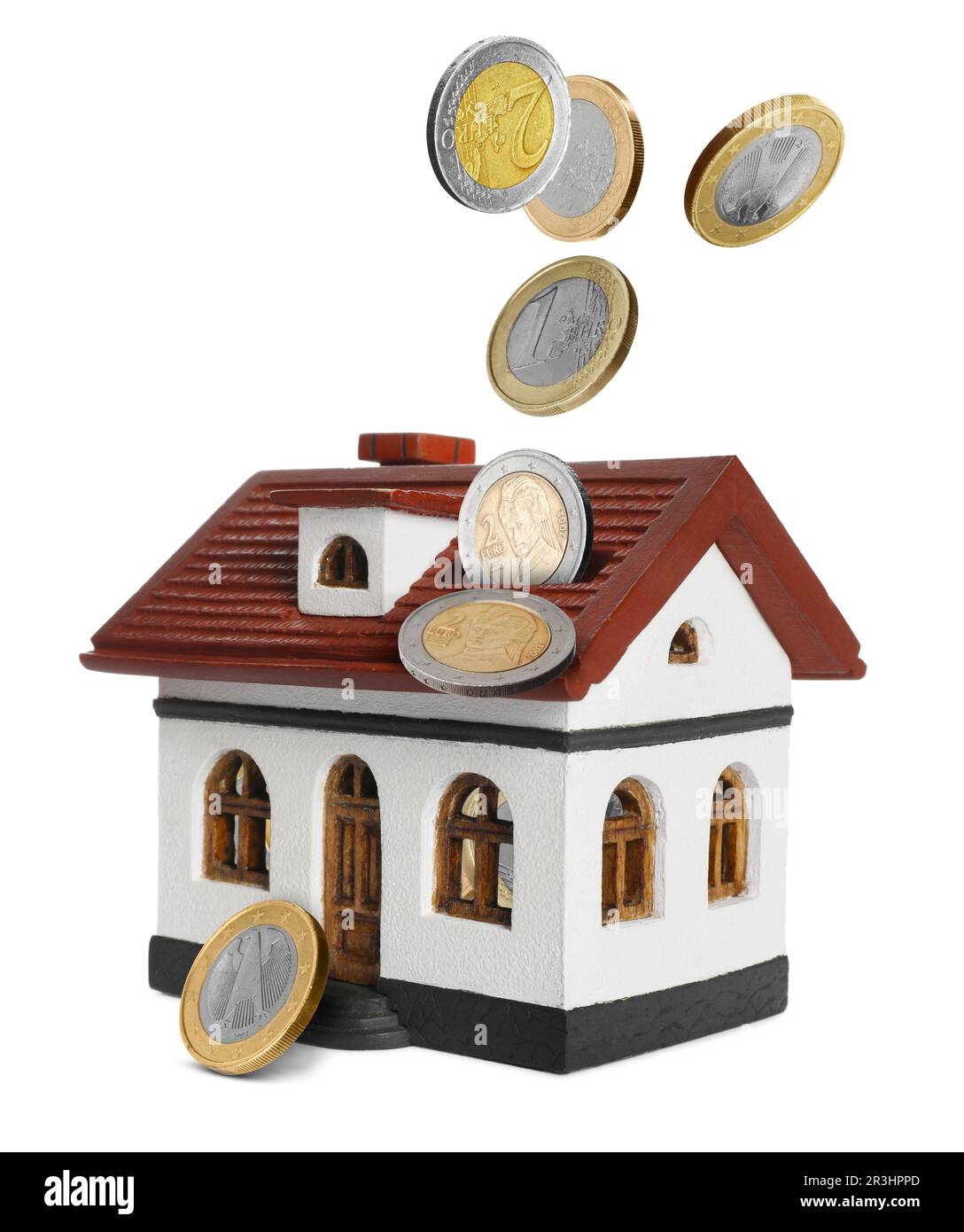 Coins falling into house shaped money box on white background Stock ...