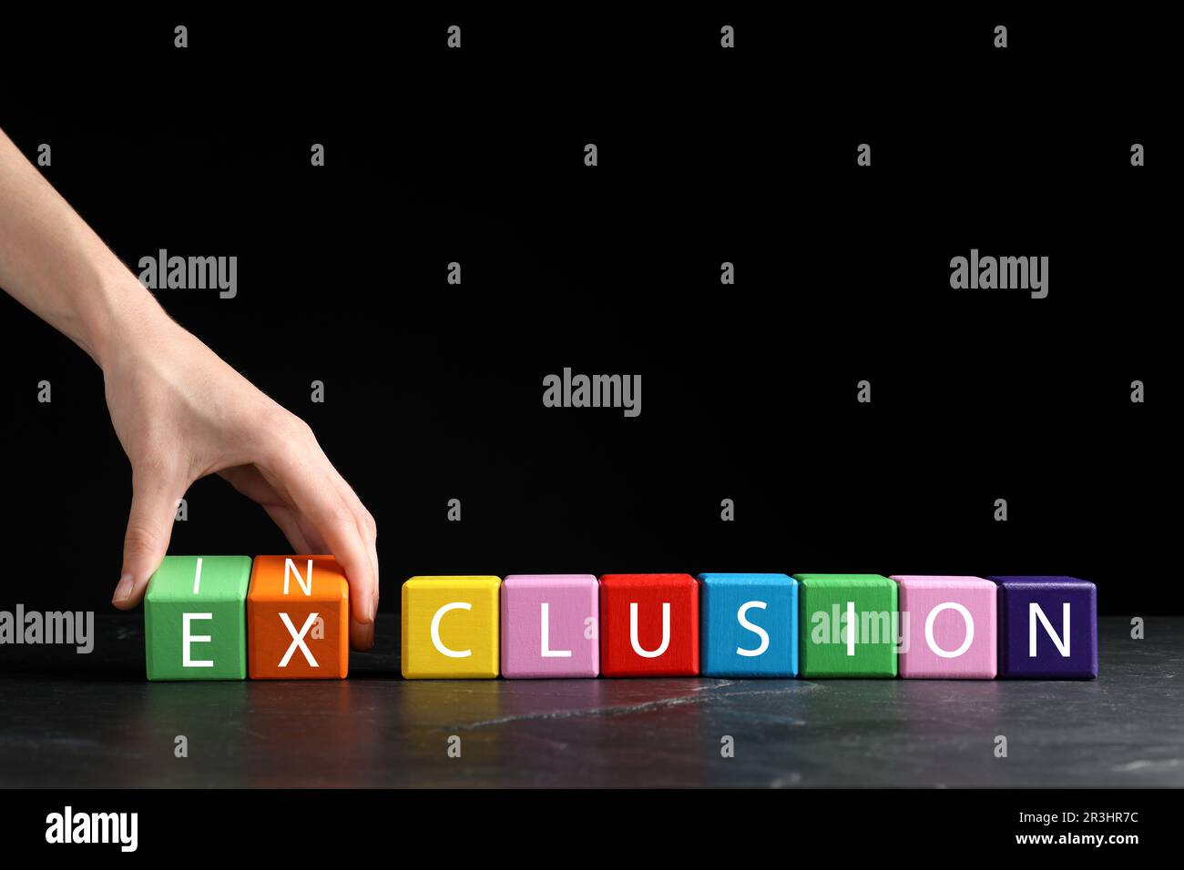 Woman making word Inclusion with colorful cubes on marble table against ...