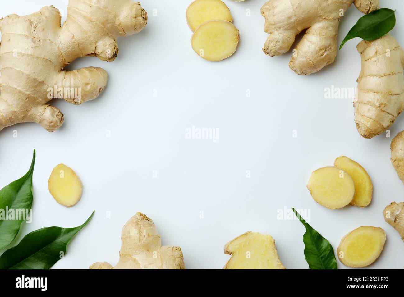 Frame of fresh ginger with green leaves on white background, flat lay ...