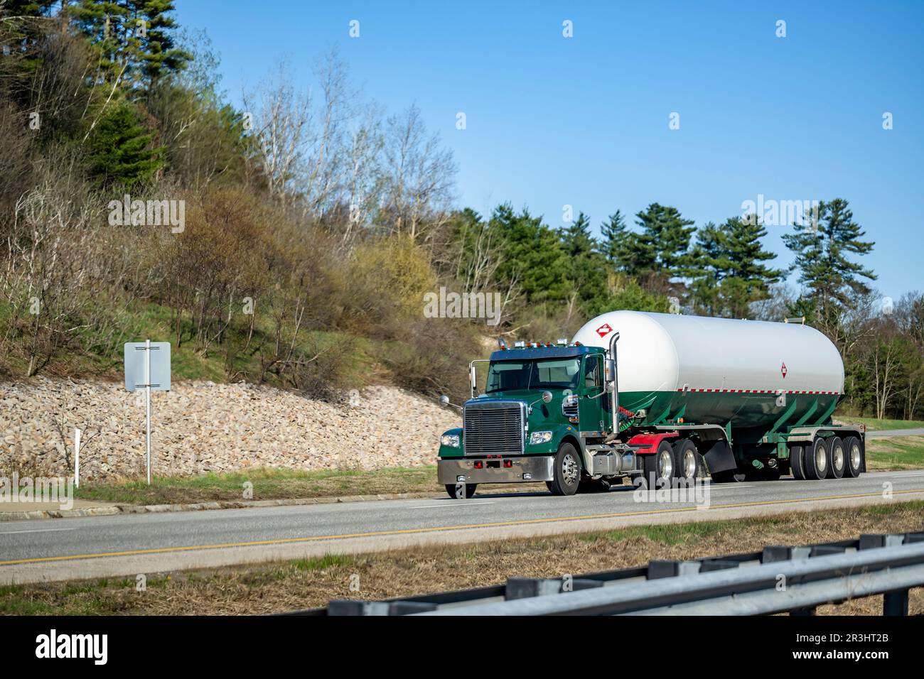 Industrial day cab green big rig semi truck transporting flammable ...