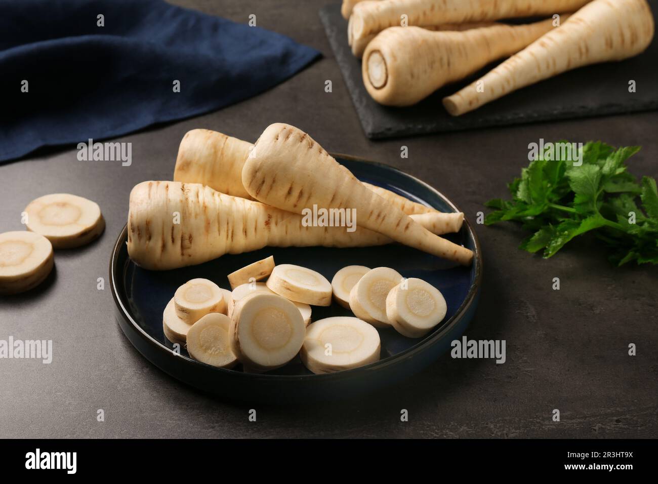 Whole and cut parsnips on black table Stock Photo - Alamy
