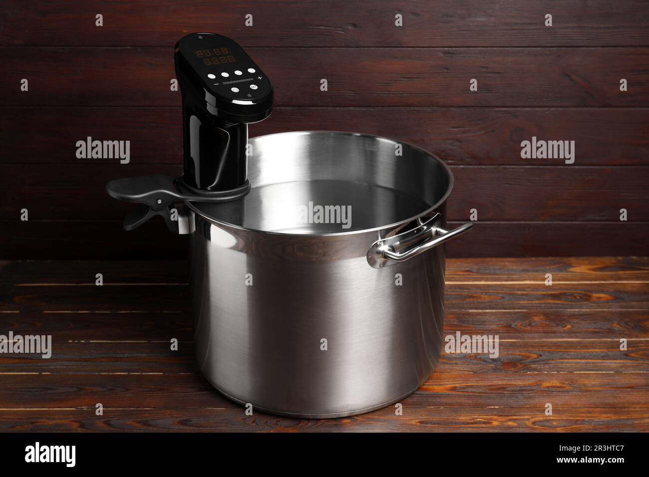 Thermal immersion circulator in pot on wooden table. Sous vide cooker ...